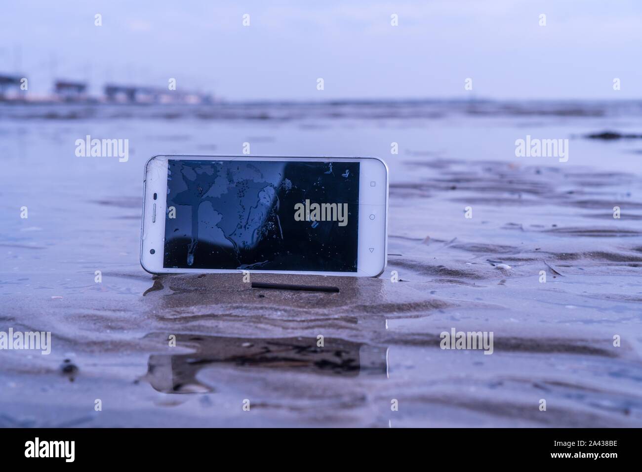 Smartphone stuck in the sand of the sea Stock Photo - Alamy