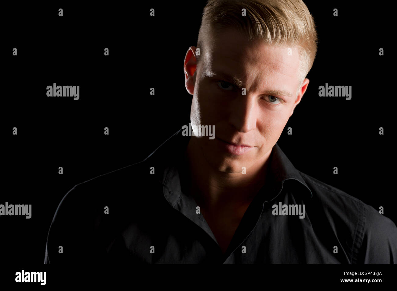 Low key portrait of young alluring man looking straight Stock Photo - Alamy