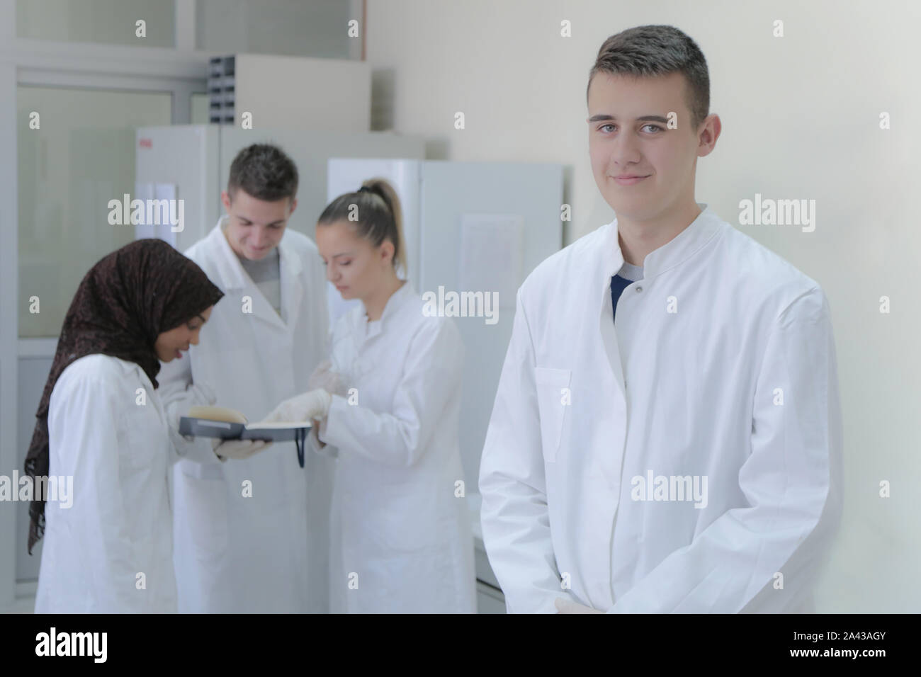 Group of young scientists doing experiments in laboratory with young ...
