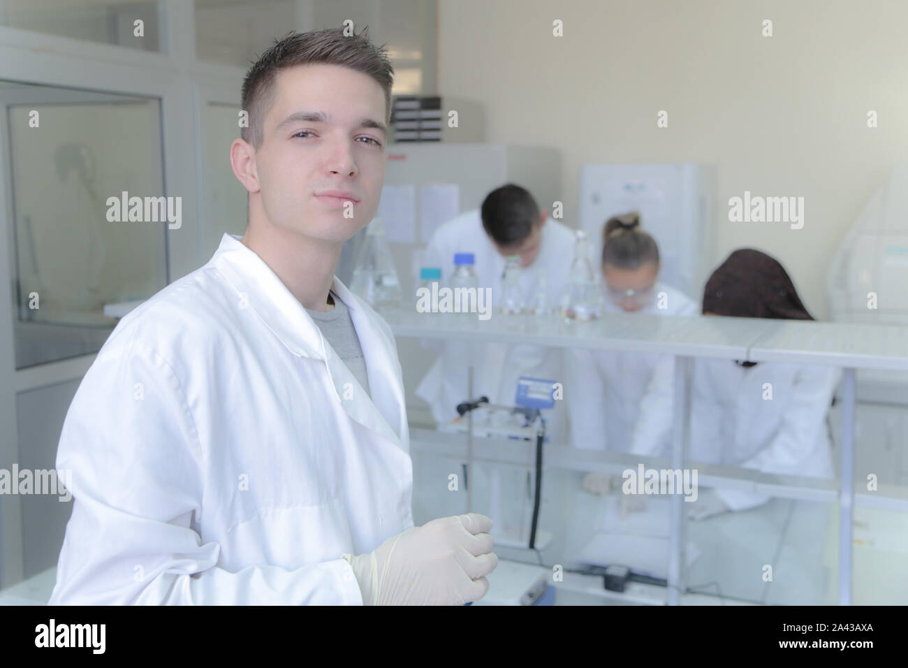 Group of young scientists doing experiments in laboratory with young ...
