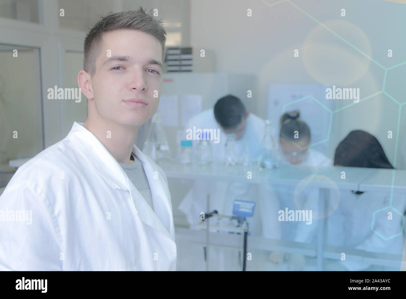 Group of young scientists doing experiments in laboratory with young ...