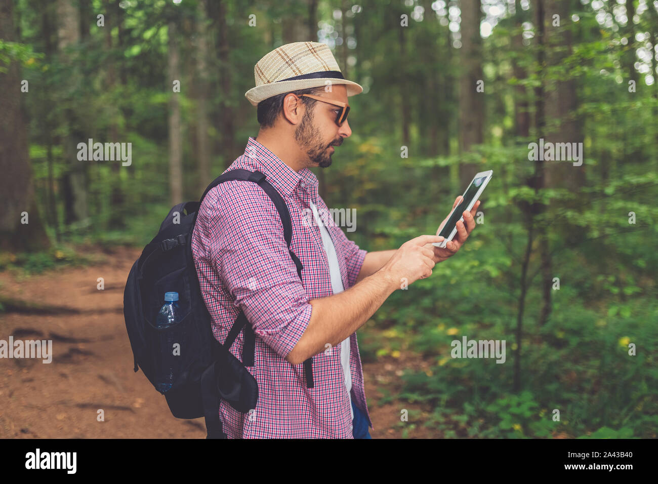 Modern hipster guy holding tablet device in nature. Travel, technology ...