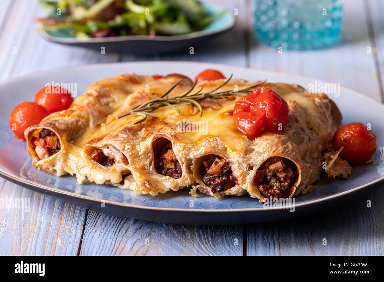 six italian canneloni pasta rolls on wood Stock Photo - Alamy