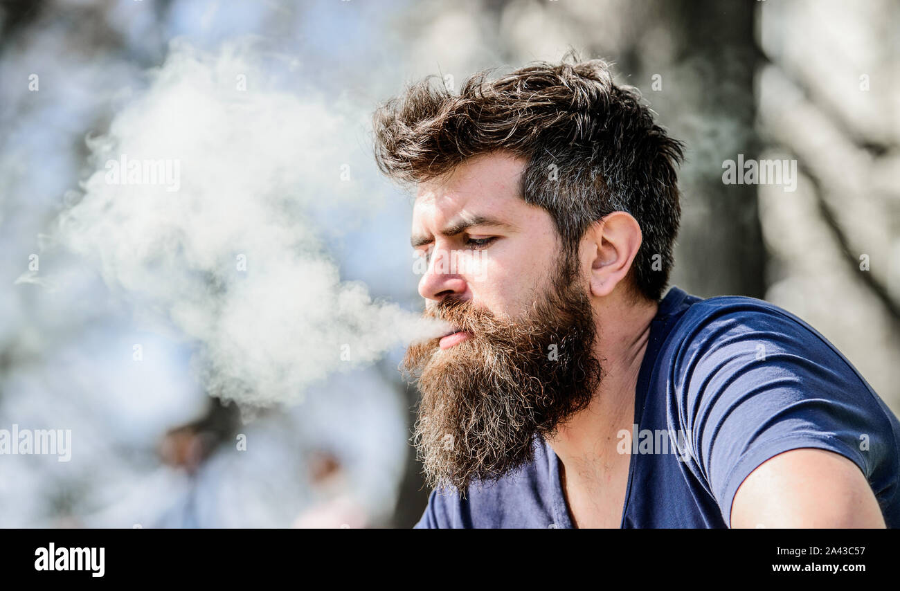 Man long beard relaxed with smoking habit. Man with beard breathe out ...