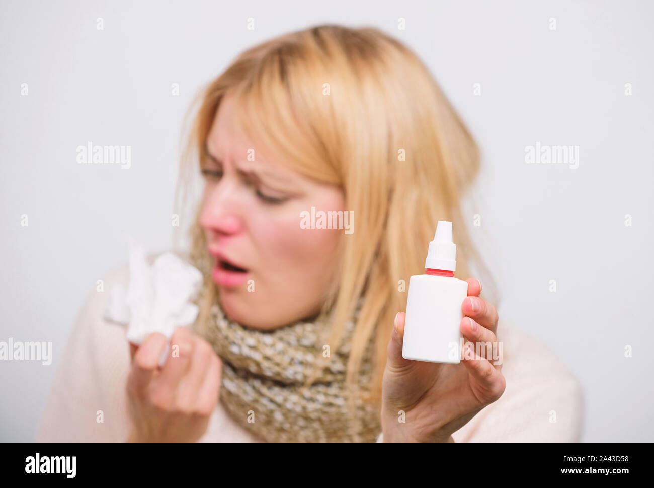 Dispenser bottle. Sick woman spraying medication into nose. Treating ...