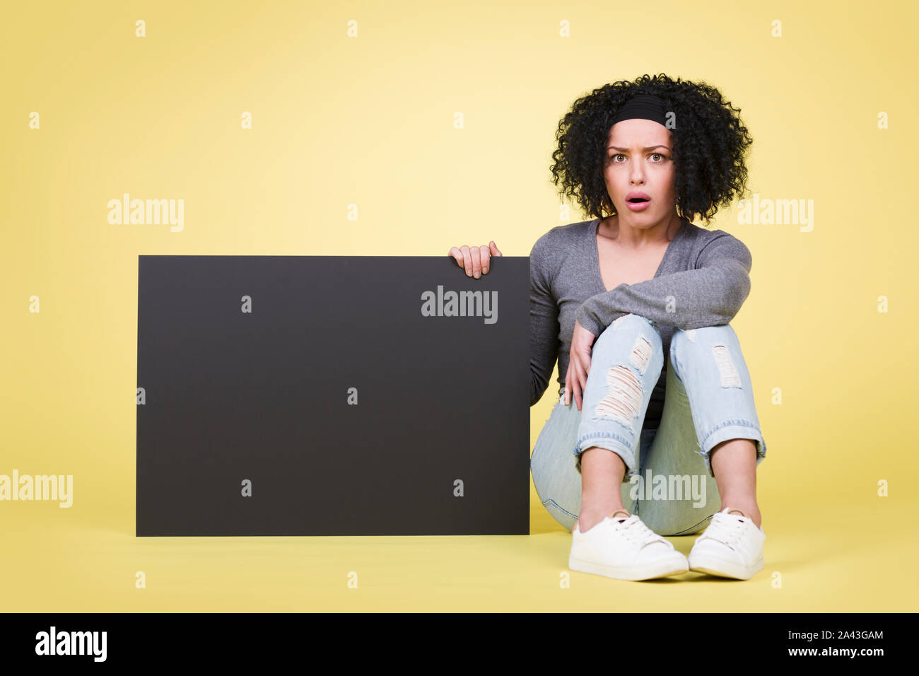 Staggered girl holding a black blank sign board with copyspace Stock ...