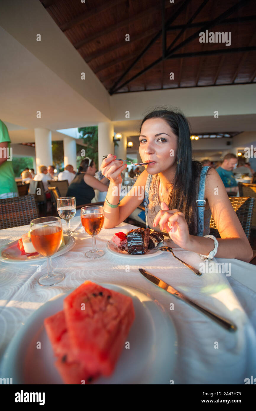 The girl sits at a full table of food. The girl in the blue dress in ...