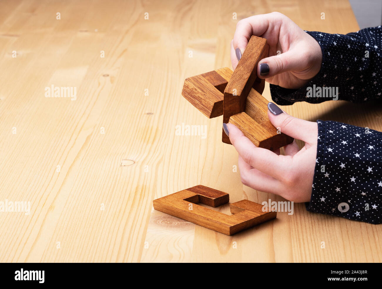 The girl is trying to solve the constructor puzzle oblique knot. Dark ...