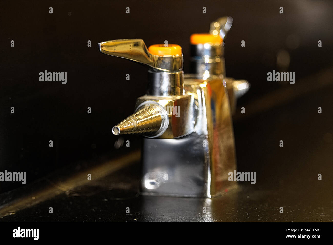 A lab gas valve on a black table and background Stock Photo - Alamy