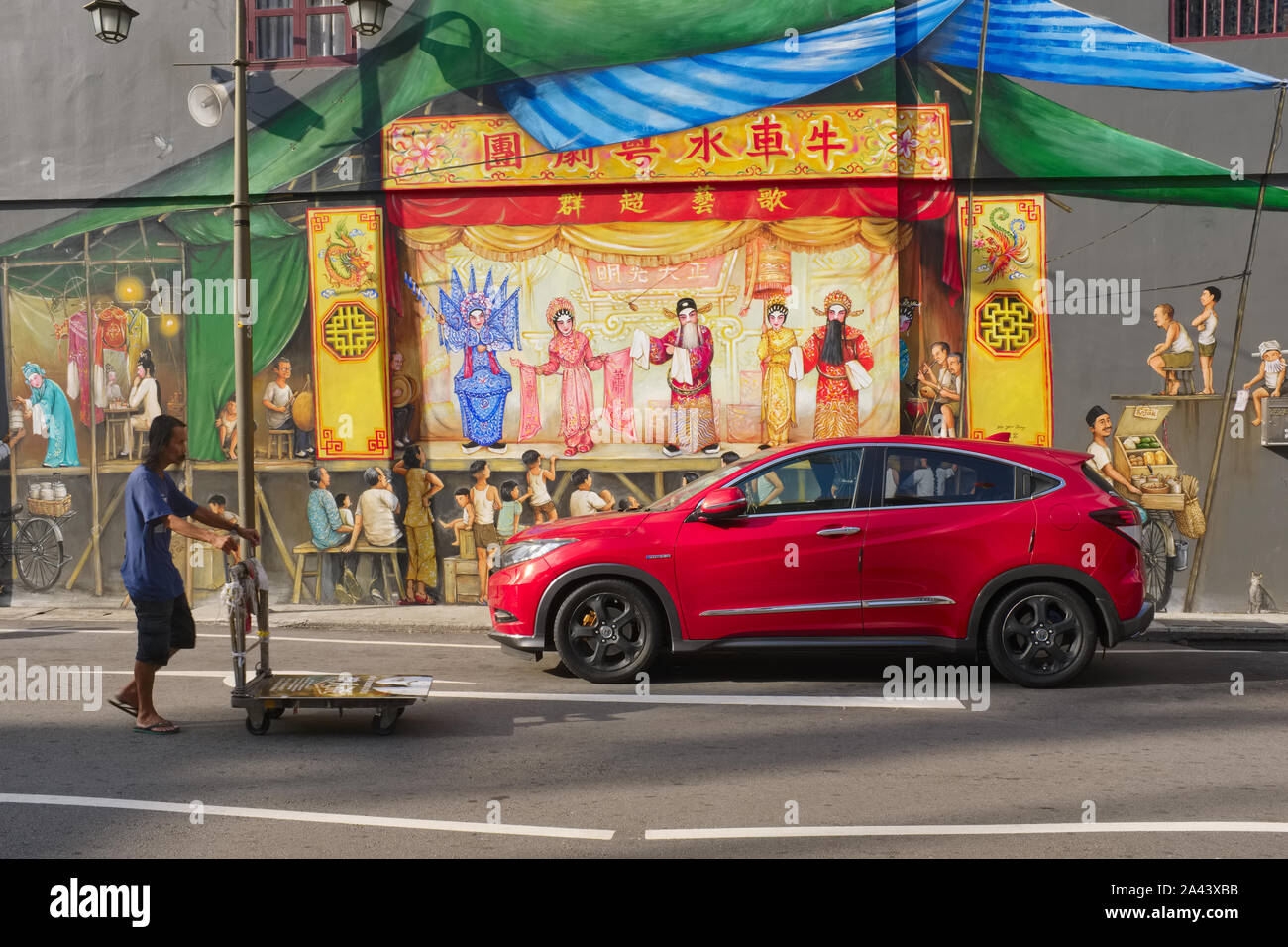 A man passes a wall painting depicting a Cantonese opera performance of ...