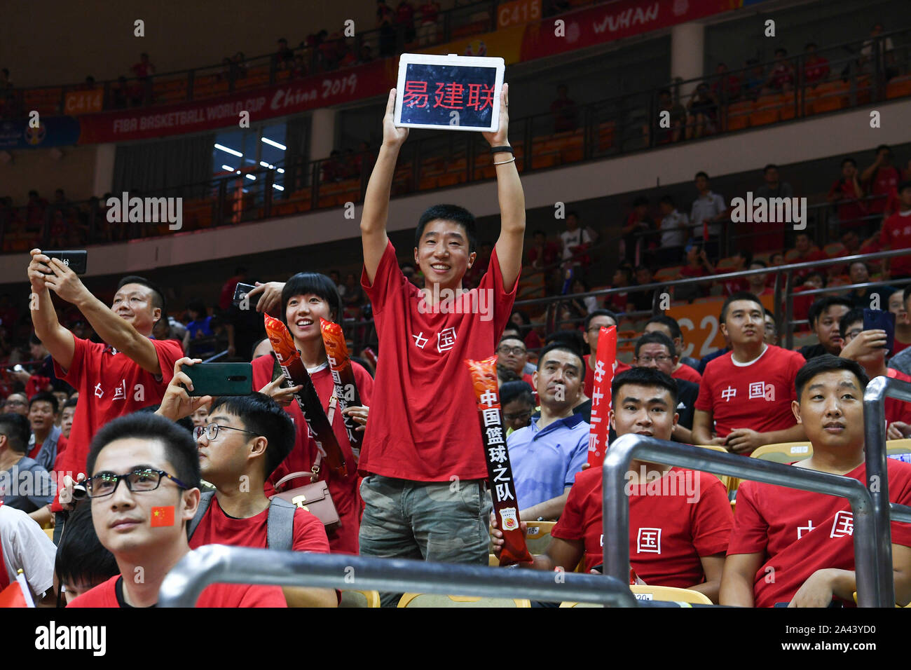 A Chinese basketball fan, middle, raises a board cheering up for Yi ...