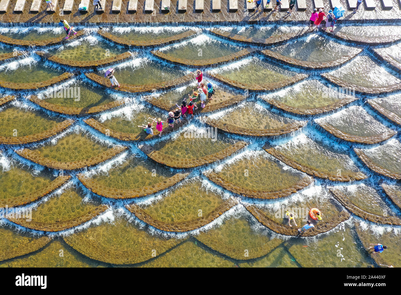 Visitors take a dip to cool off in water in a location known for fish ...