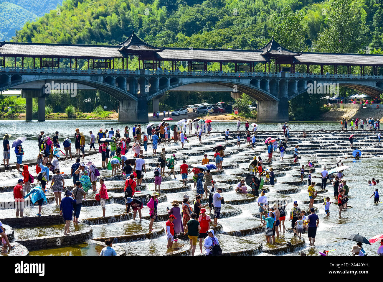 Visitors take a dip to cool off in water in a location known for fish ...