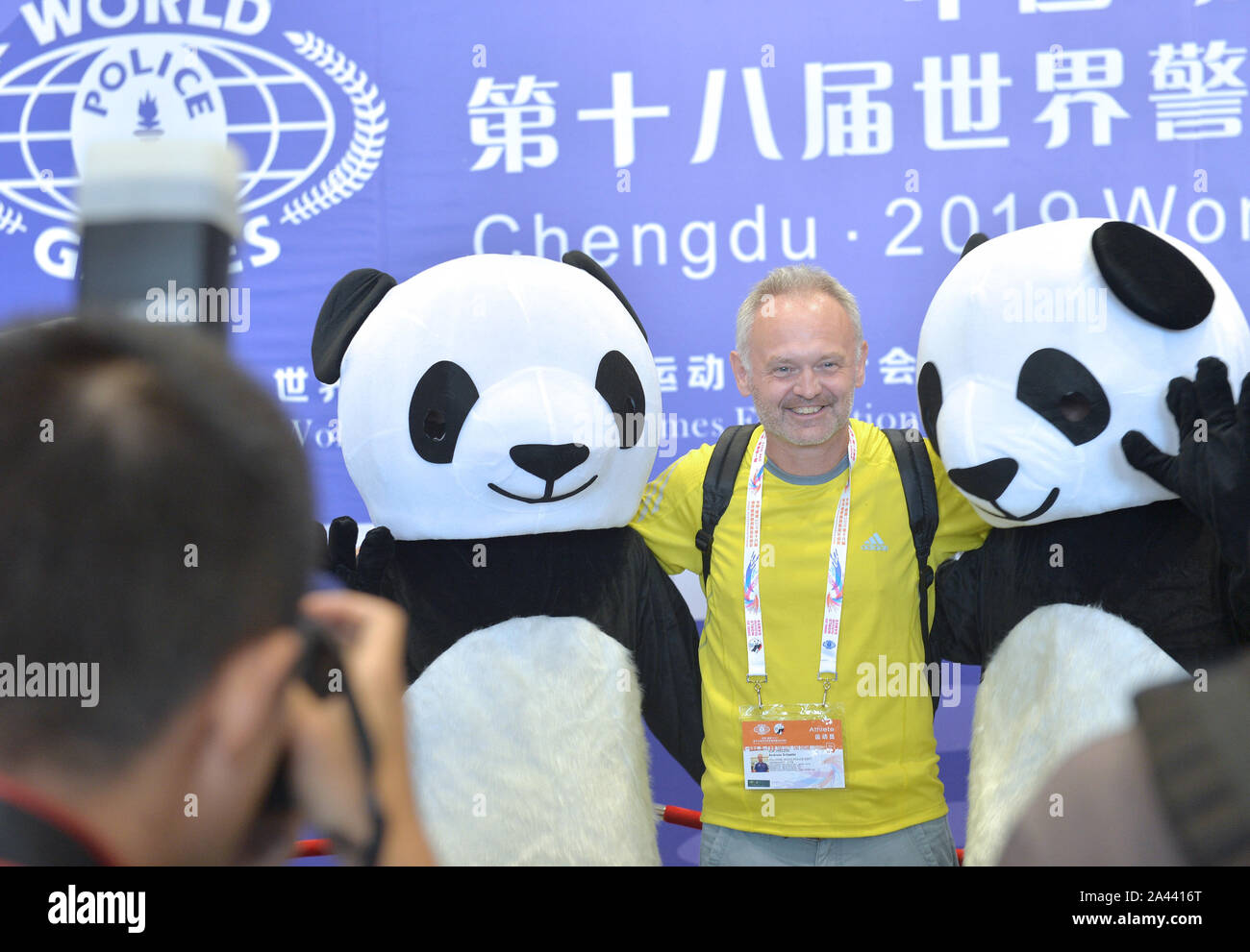 A guest poses for photos with Chinese workers dressed in giant panda ...