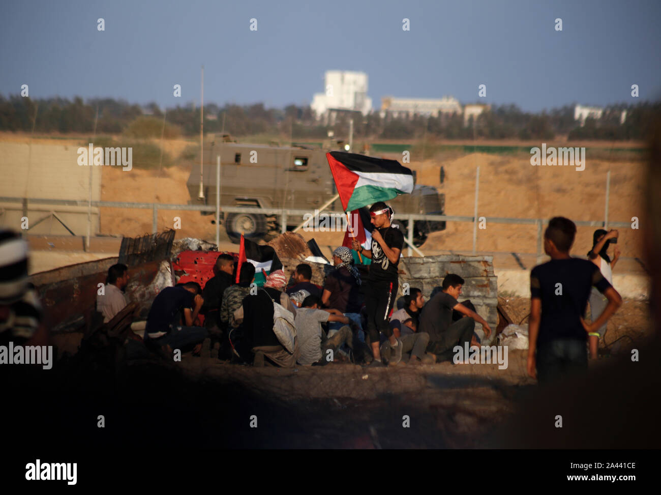 Palestinian demonstrators hide behind an iron curtain during an anti ...