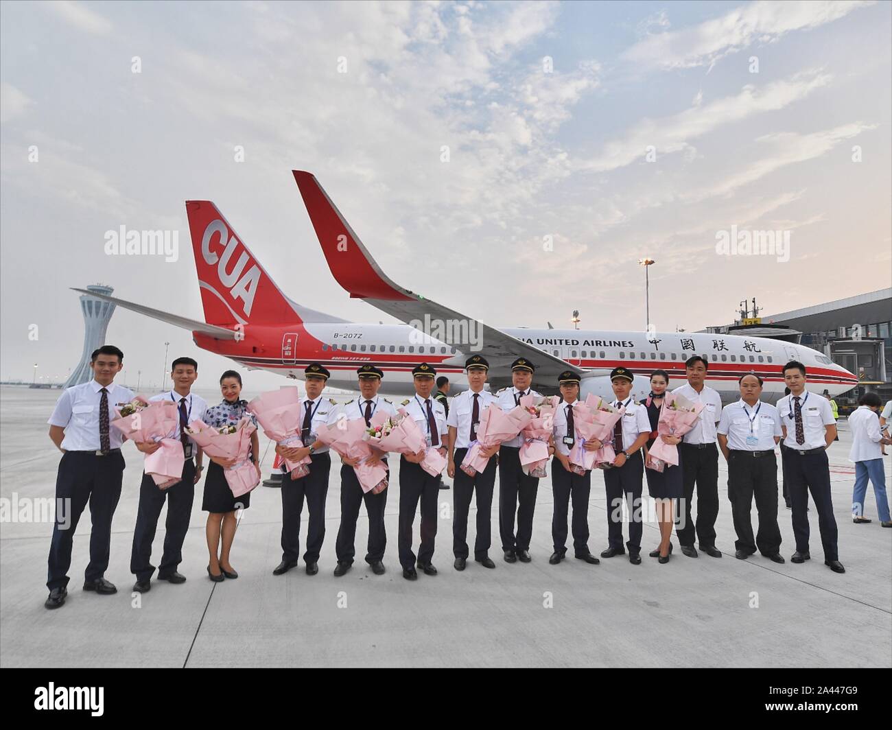 Chinese crew members pose for photos in front of a jet plane of China ...