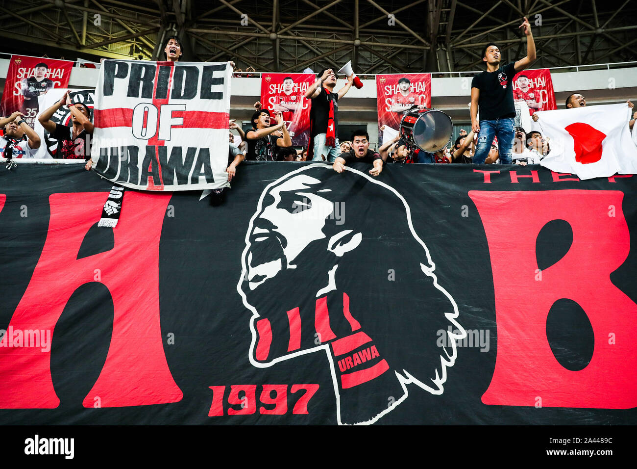 Fans cheer for the Urawa Red Diamonds team at the stand at the Shanghai ...