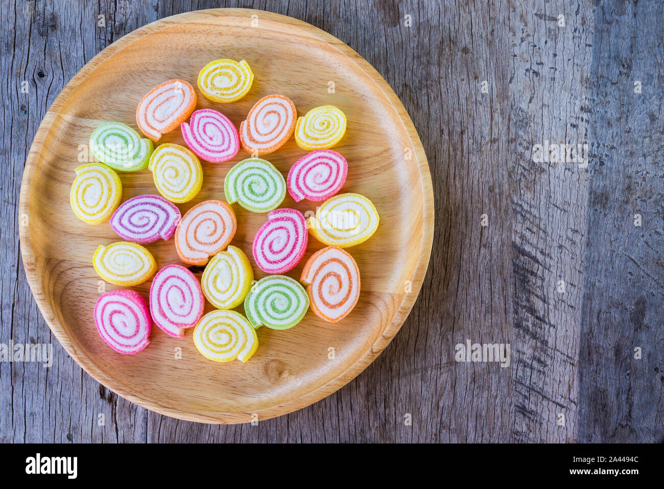 Colorful gummy candy on wooden dish and on wooden background. Copy ...