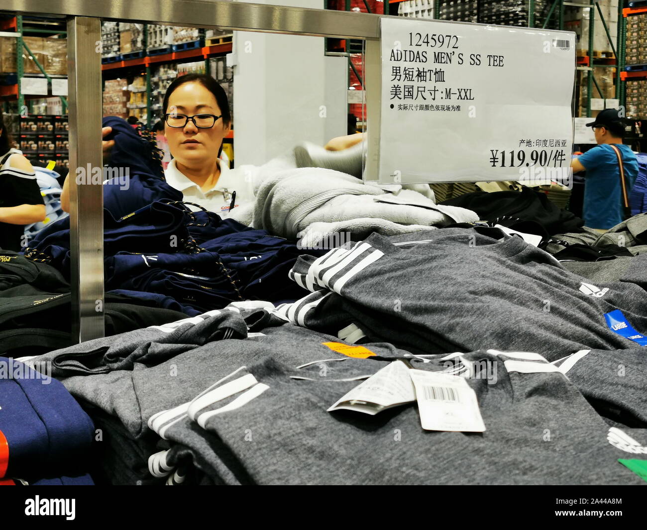 A Chinese employee sorts out clothes at the Costco store in Shanghai ...