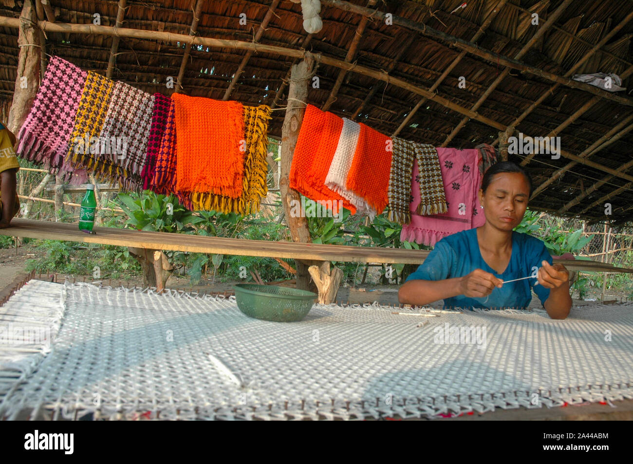 A girl from the ethnic Rakhain community weaving cloth with a ...