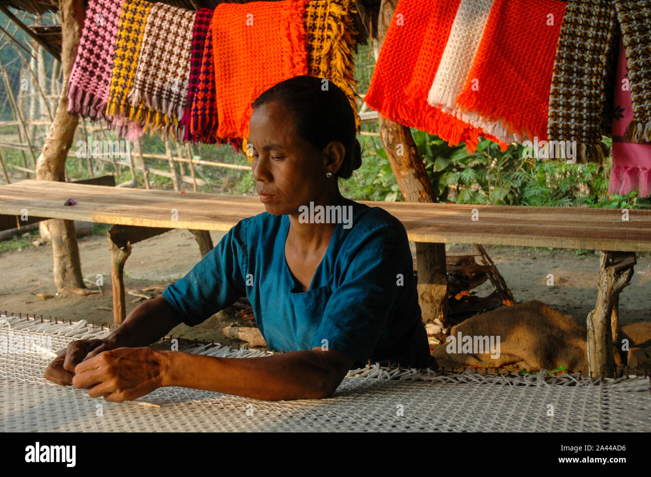 A girl from the ethnic Rakhain community weaving cloth with a ...