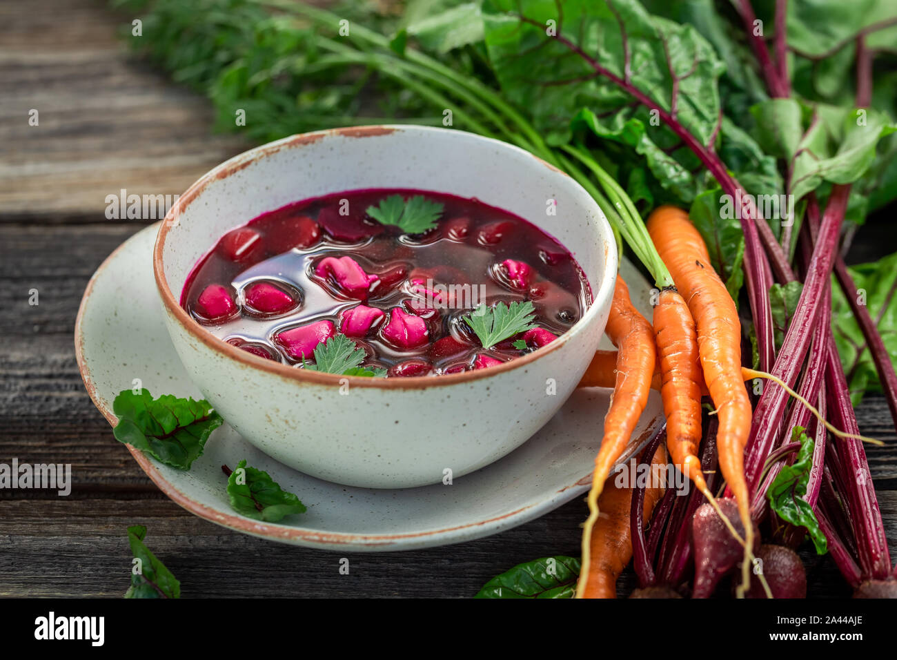 Closeup of beetroot soup with dumplings on wooden table Stock Photo - Alamy