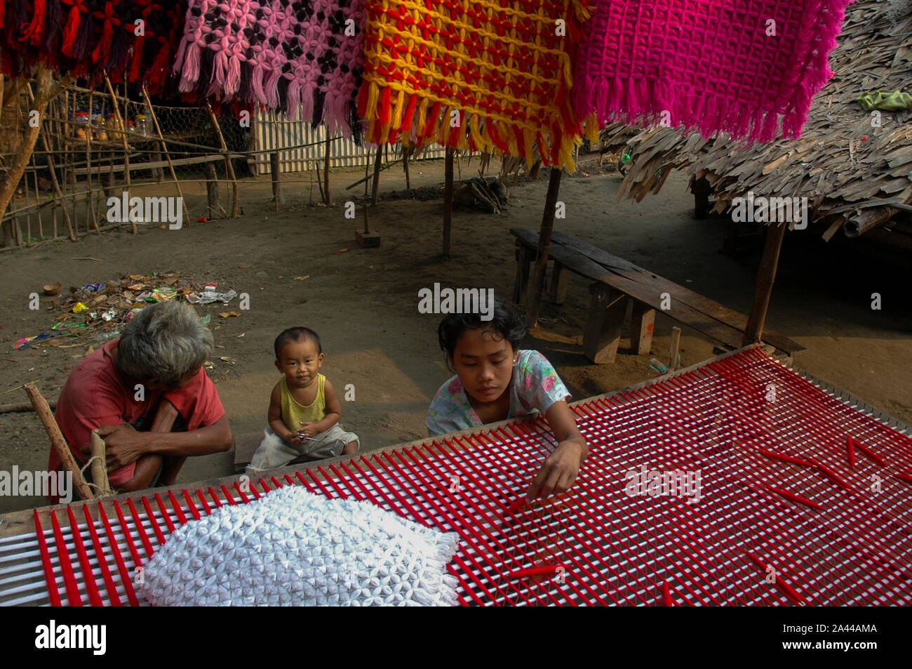 A girl from the ethnic Rakhain community weaving cloth with a ...