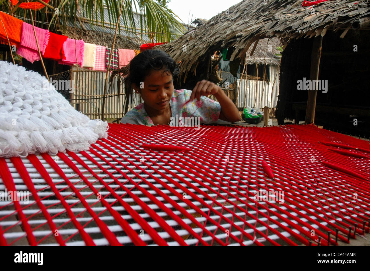 A girl from the ethnic Rakhain community weaving cloth with a ...