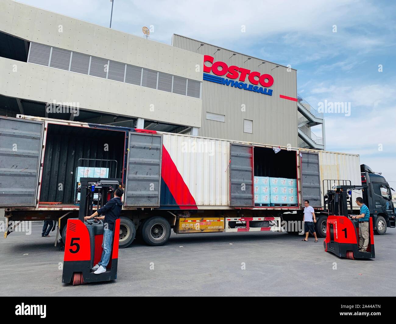 Chinese workers unload products from a truck at the first brick-and ...