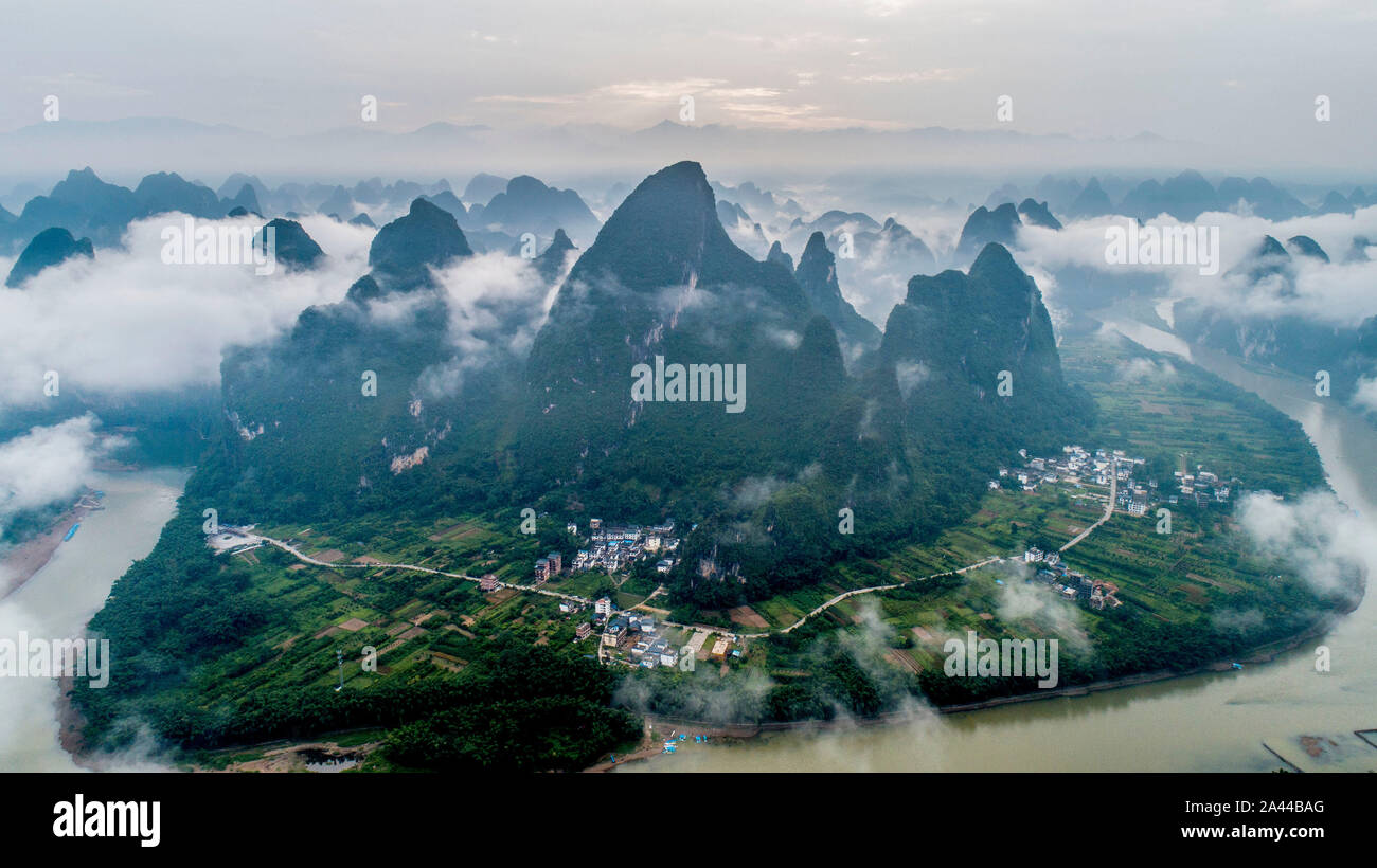 The mountains and hills are surrounded by mist and cloud along the Li ...