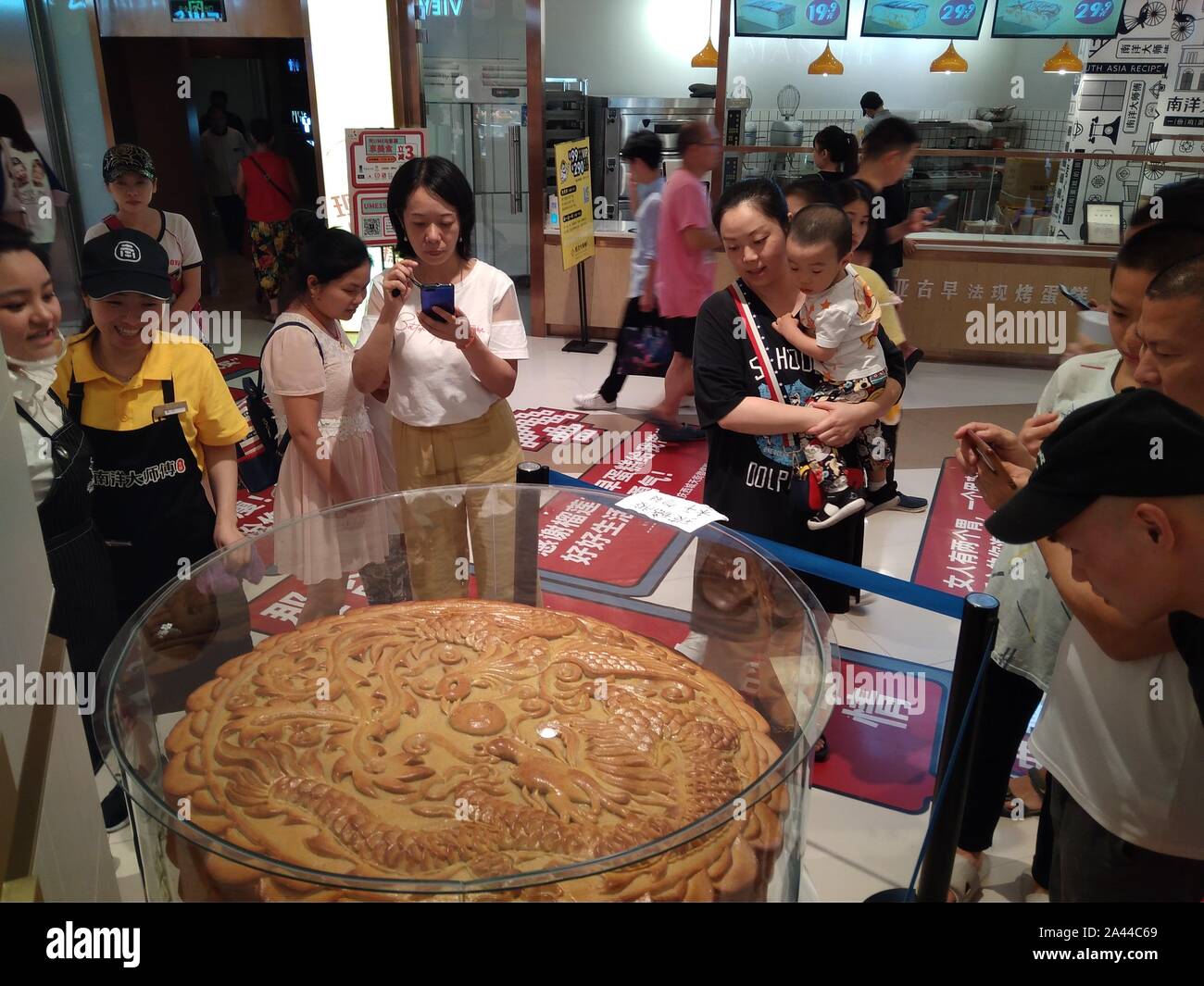 Customers view a huge mooncake weighed 400 kilograms in front of a ...