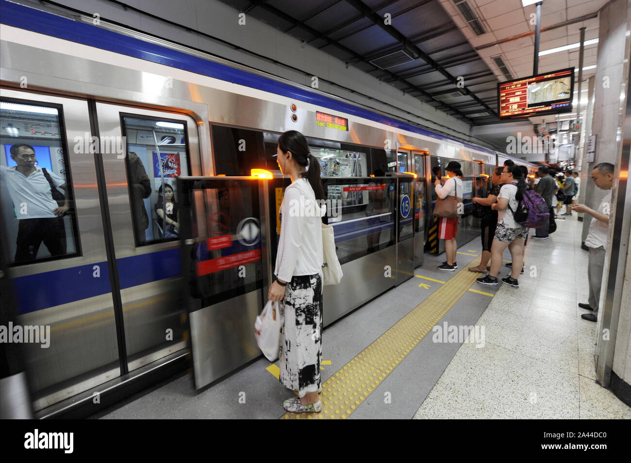 Passengers wait for their trains beside a logo showing strong and weak ...