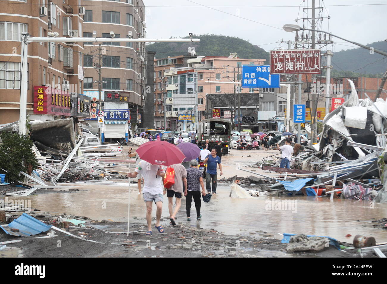 Local residents walk on a flooded road after heavy rainstorm caused by ...