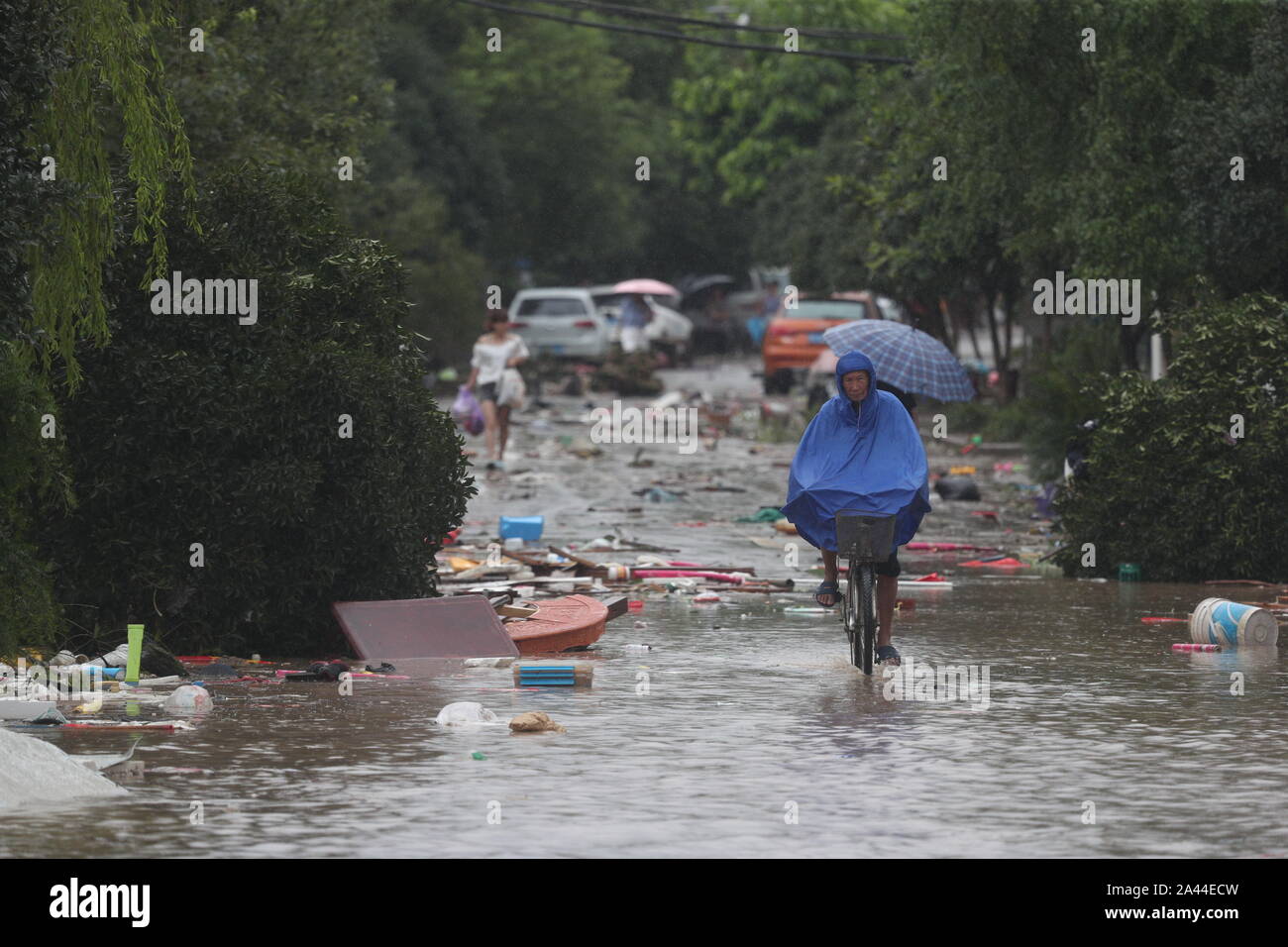 A cyclist rides on a flooded road after heavy rainstorm caused by ...