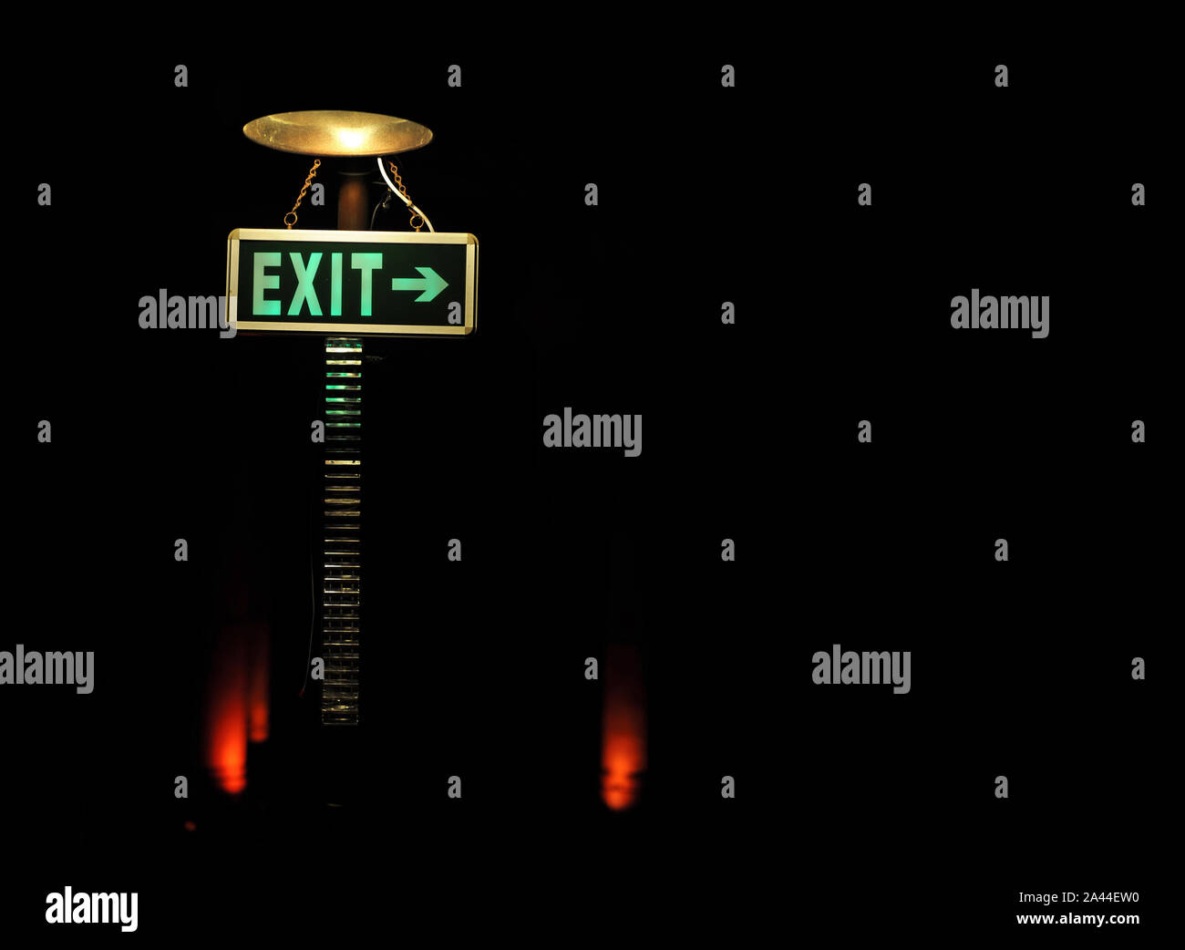 Green exit sign under lamp on a post in a cozy comfortable dim place ...