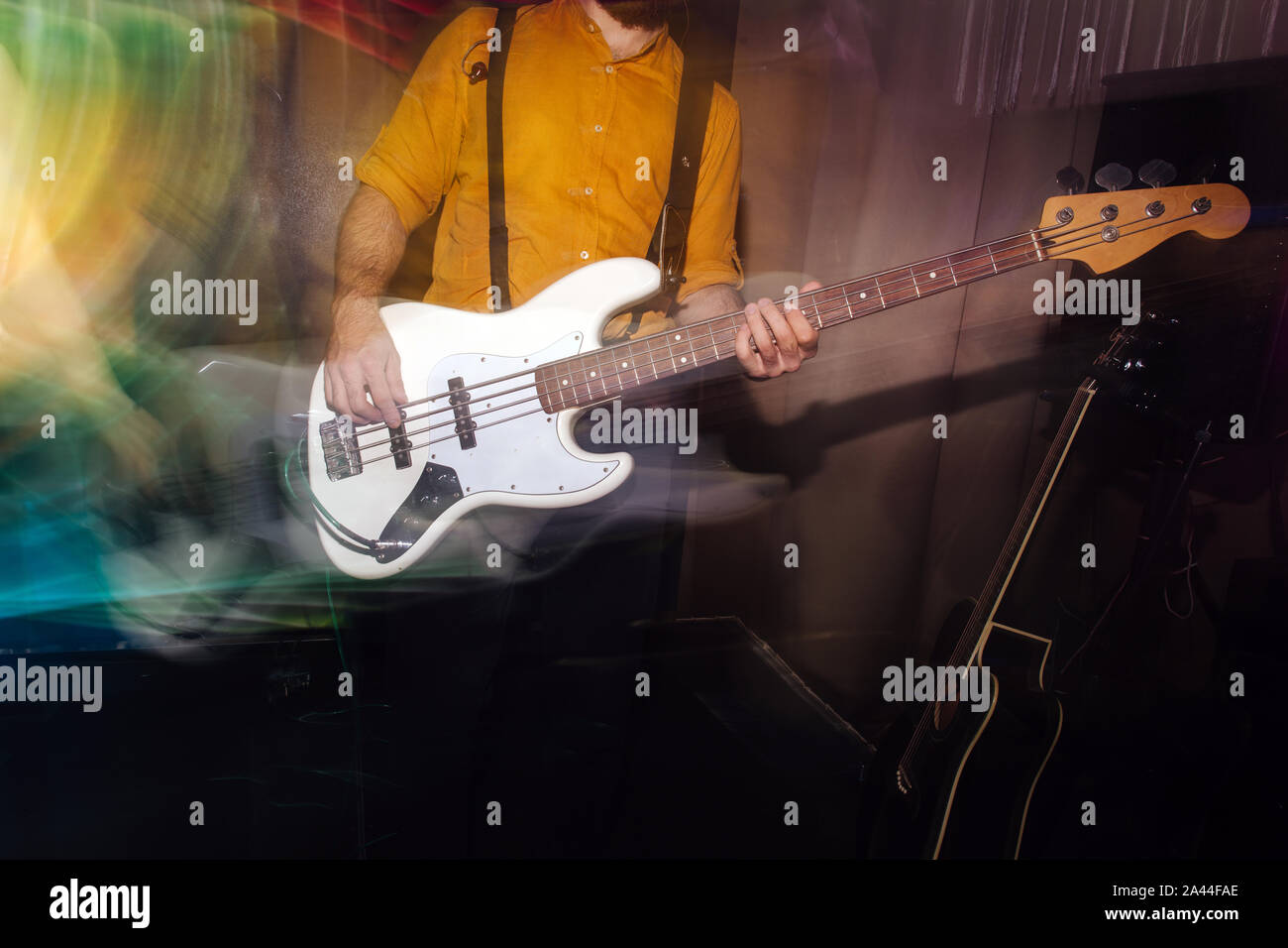 Bas gitarist playing on the white guitar, motion blurred with ...