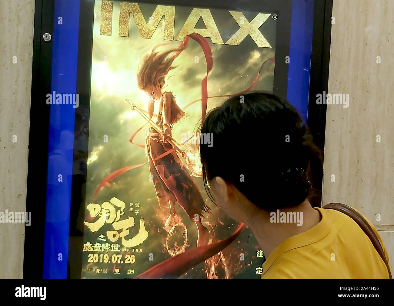 A Chinese filmgoer views a poster of Chinese animated film "Ne Zha" at ...