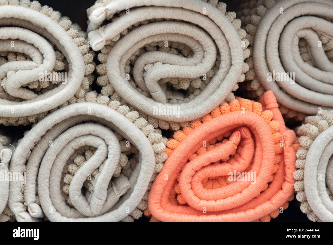 New rolled up bath mats on a store counter Stock Photo - Alamy