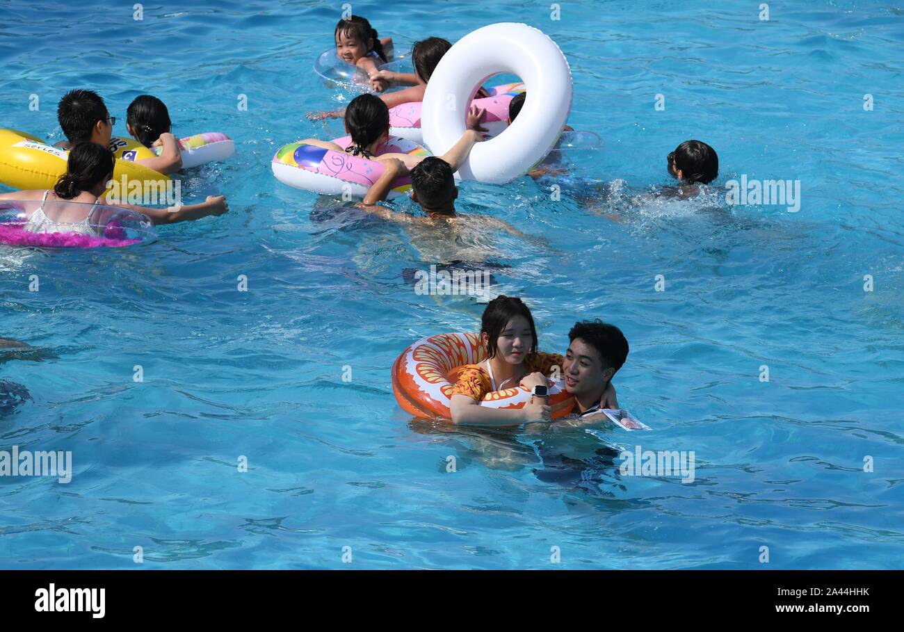 Chinese holidaymakers crowd a swimming pool at a water park to escape ...