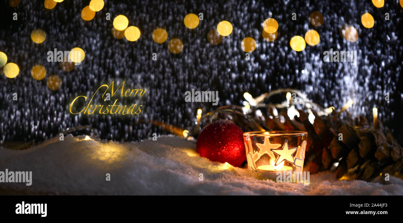 christmas theme with candles, snow, pinecone and christmas light with ...