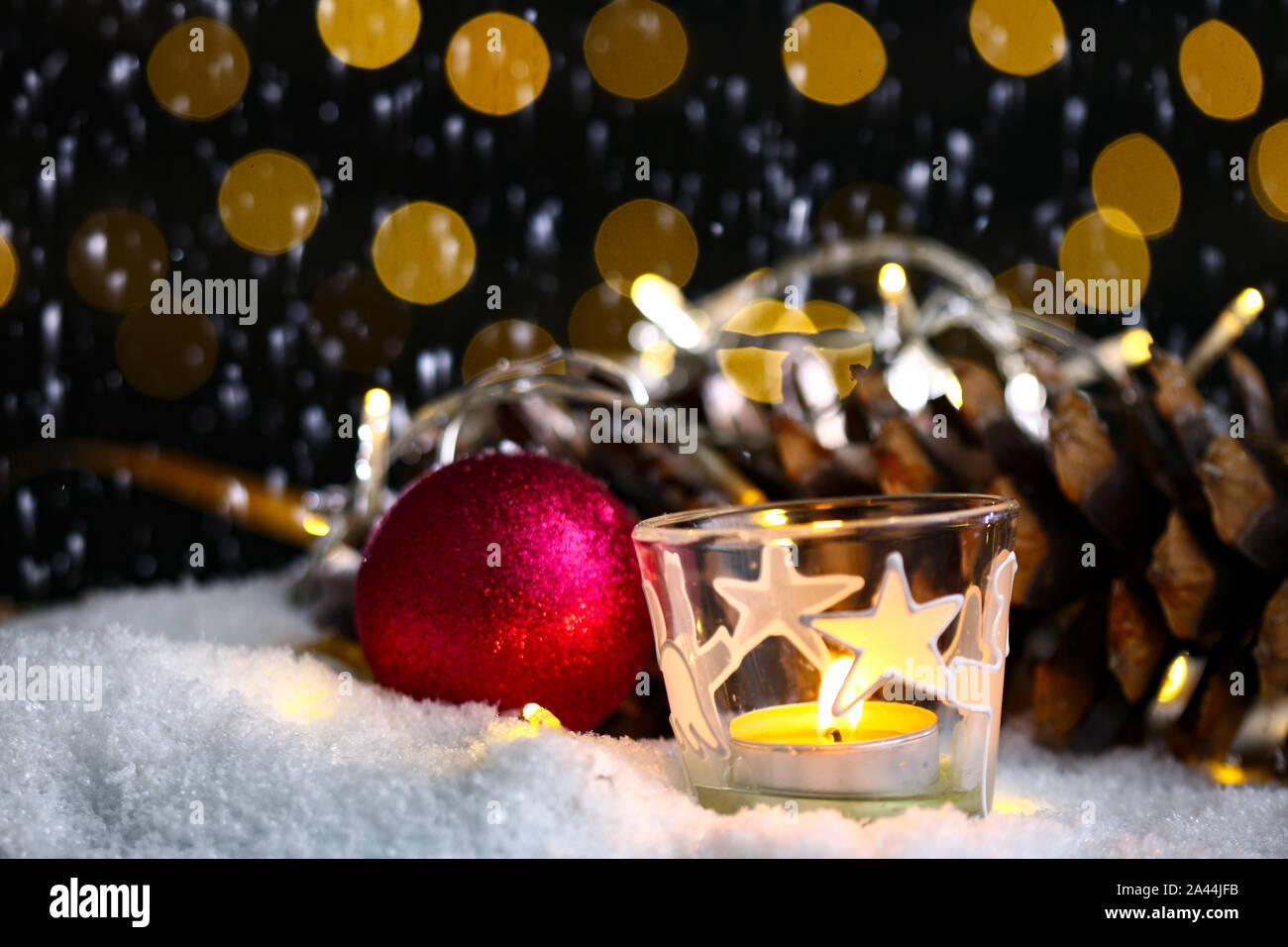 christmas theme with candles, snow, pinecone and christmas light with ...