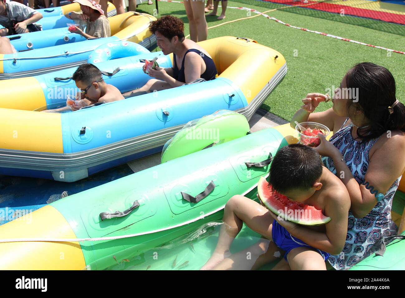 Tourists enjoy watermelon added with zhacai, or pickled mustard stems ...