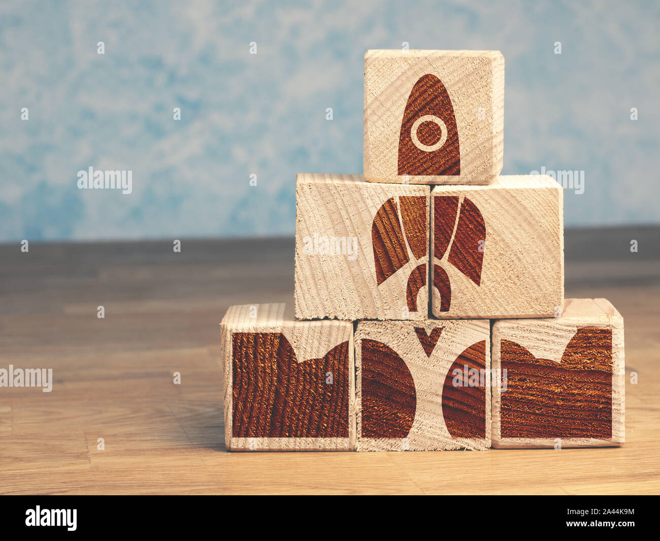 Pyramid of wooden blocks with an abstract rocket, start up concept ...
