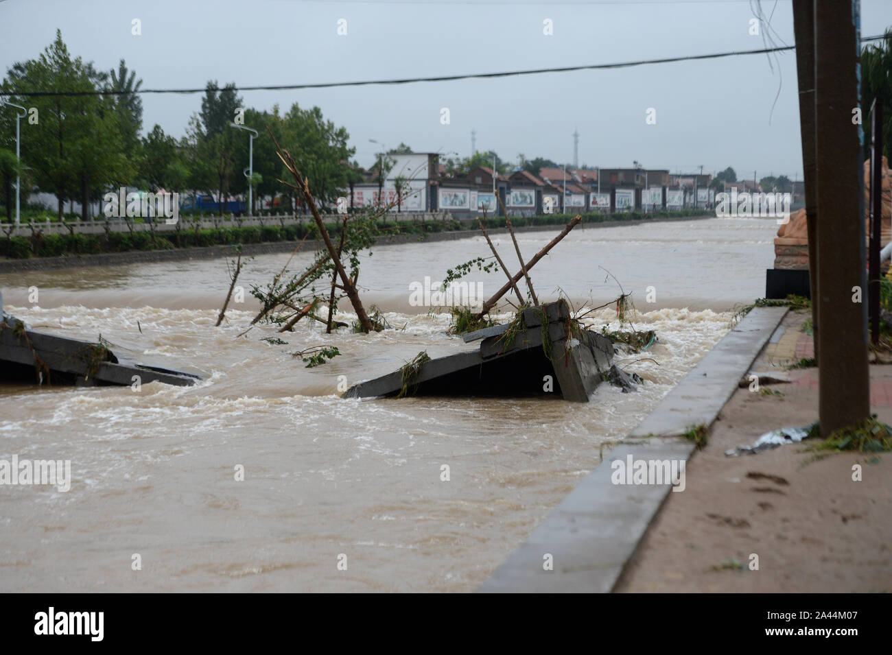 A bridge is devastated by the floodwater due to rainstorms caused by ...