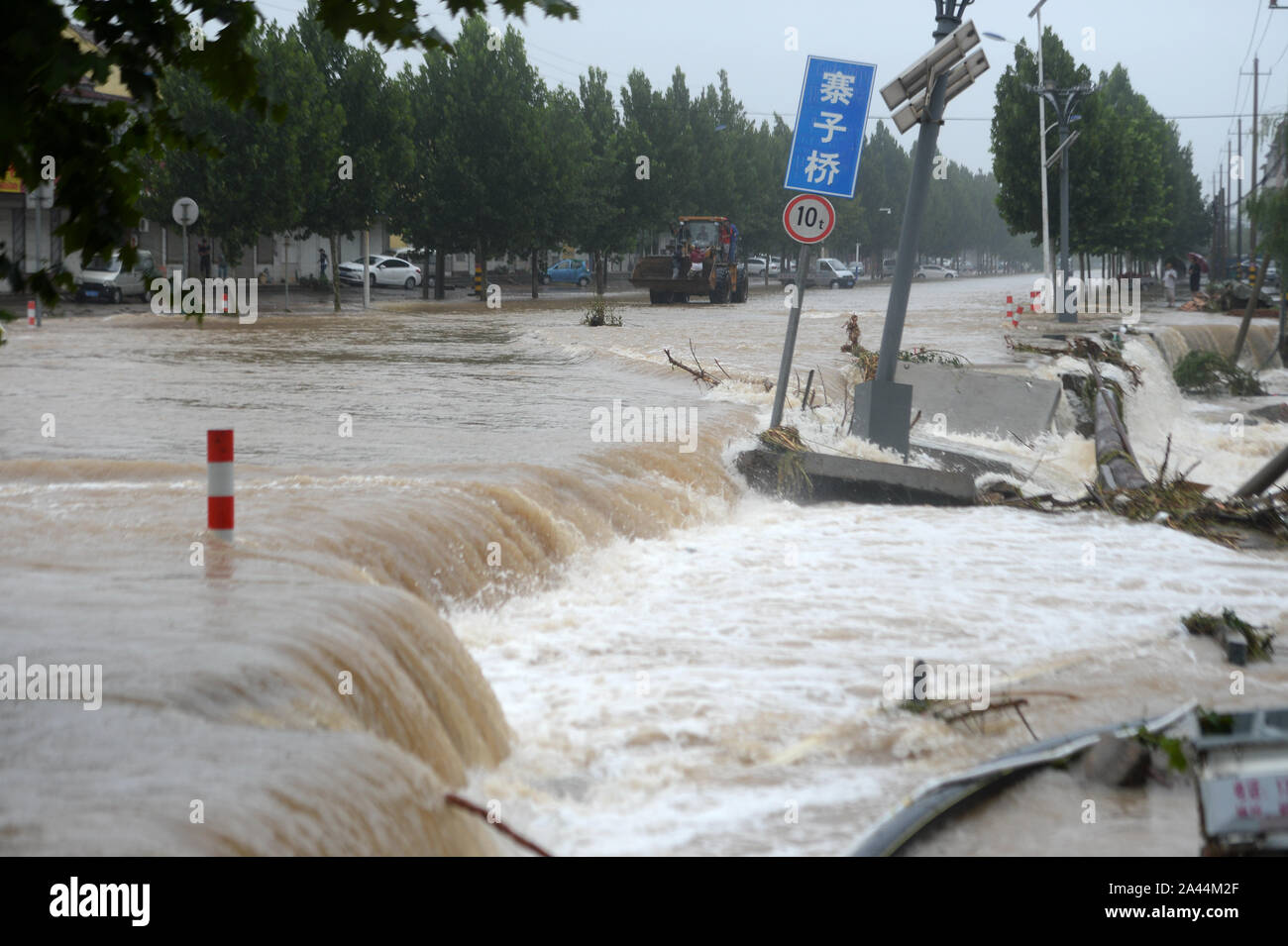 A bridge is devastated by the floodwater due to rainstorms caused by ...