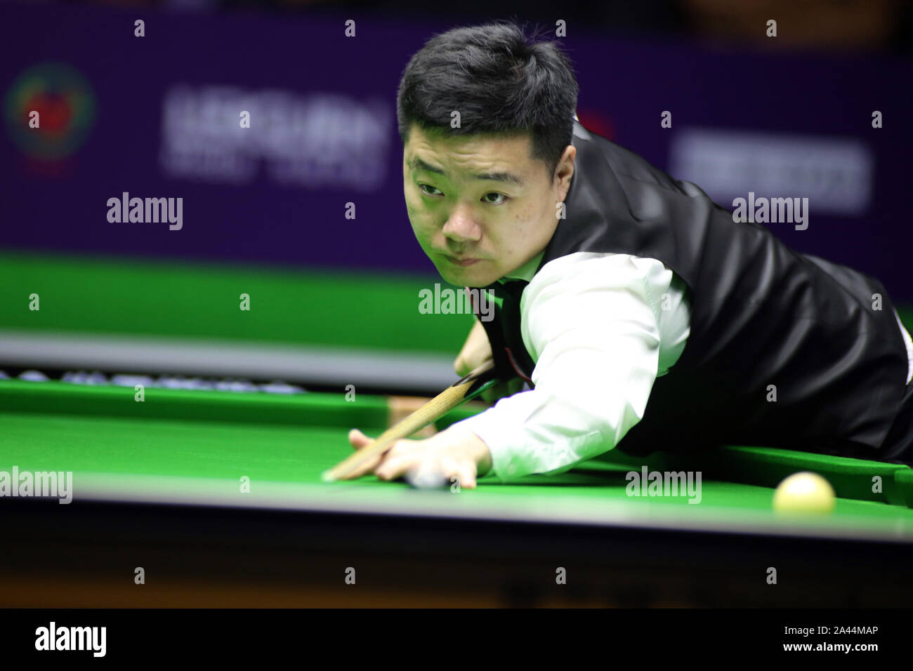 Ding Junhui of China plays a shot to Zhao Xintong of China in the first ...