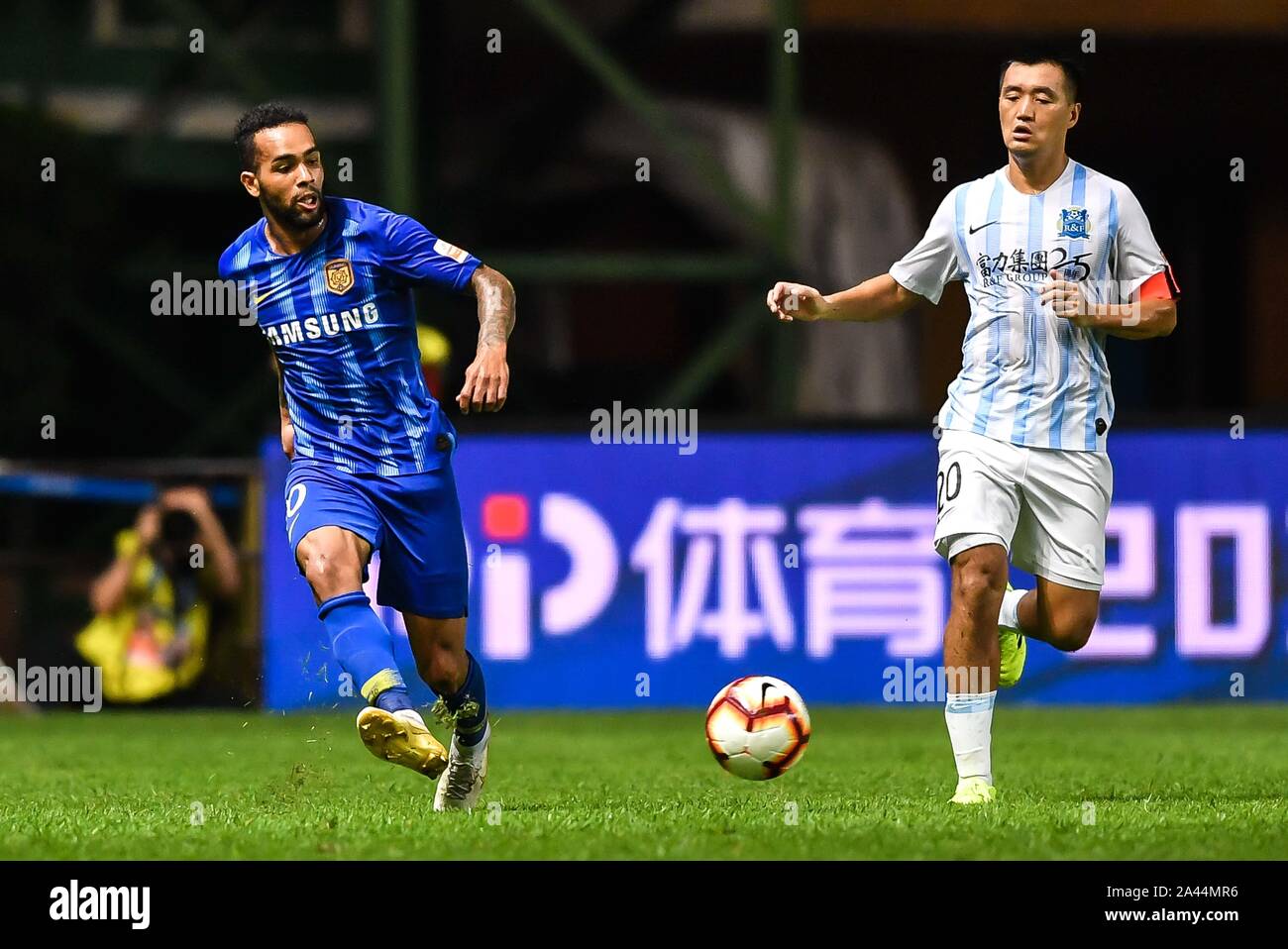 Brazilian football player Alex Teixeira, left, of Jiangsu Suning passes ...