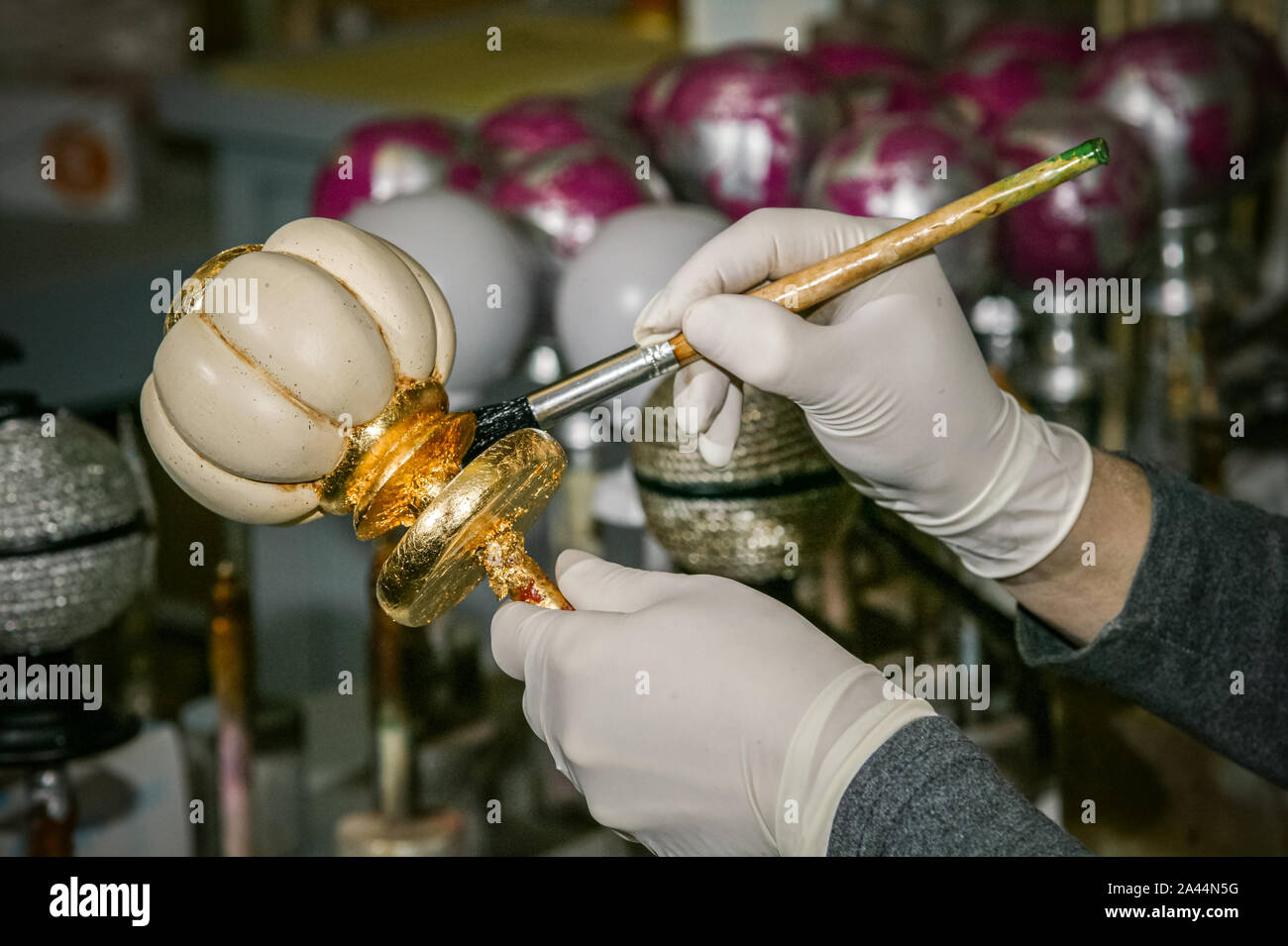 Master craftswoman during the gilding process tecnique with leaf gold ...