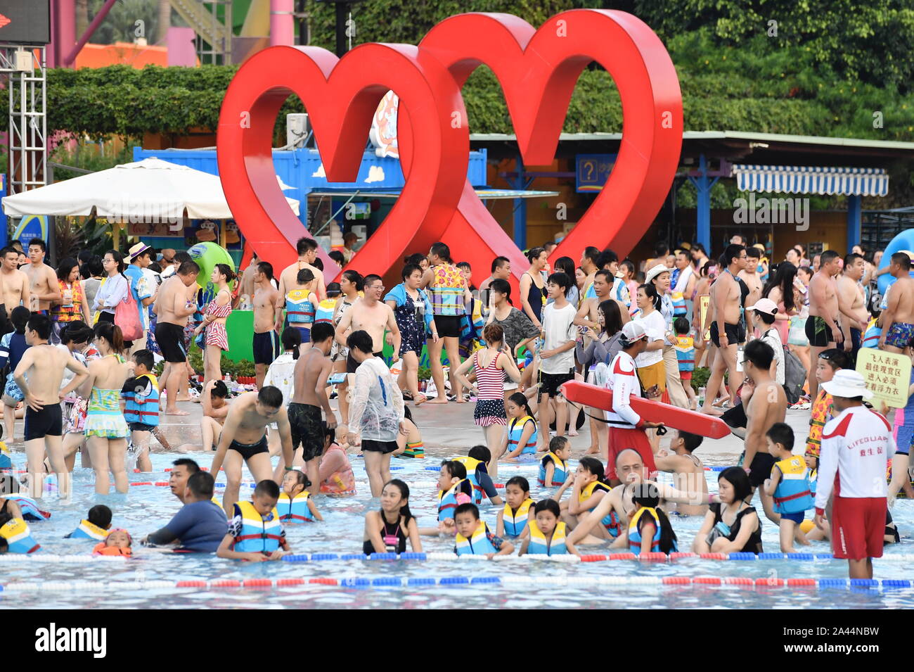 Tourists crowd a swimming pool at the Chimelong Water Park to cool off ...