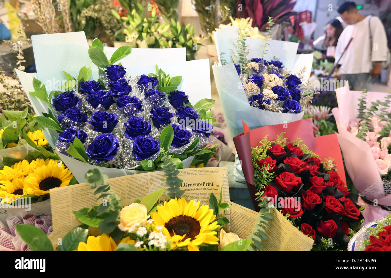 Chinese workers display flowers at a flower market ahead of traditional ...